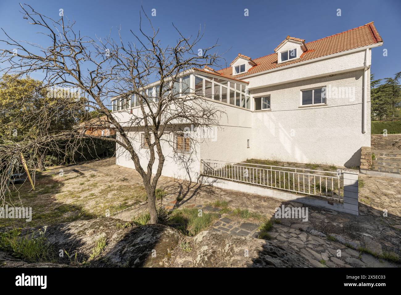 Rear facade of a chalet with a plot covered with granite stone floors ...
