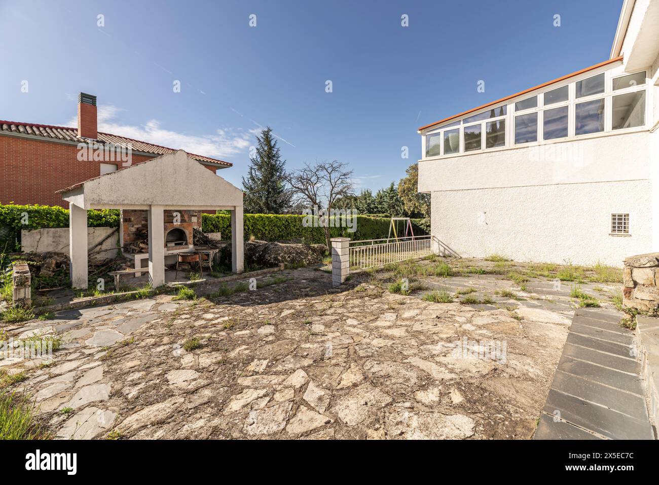 Rear facade of a chalet with a covered plot with granite stone floors ...