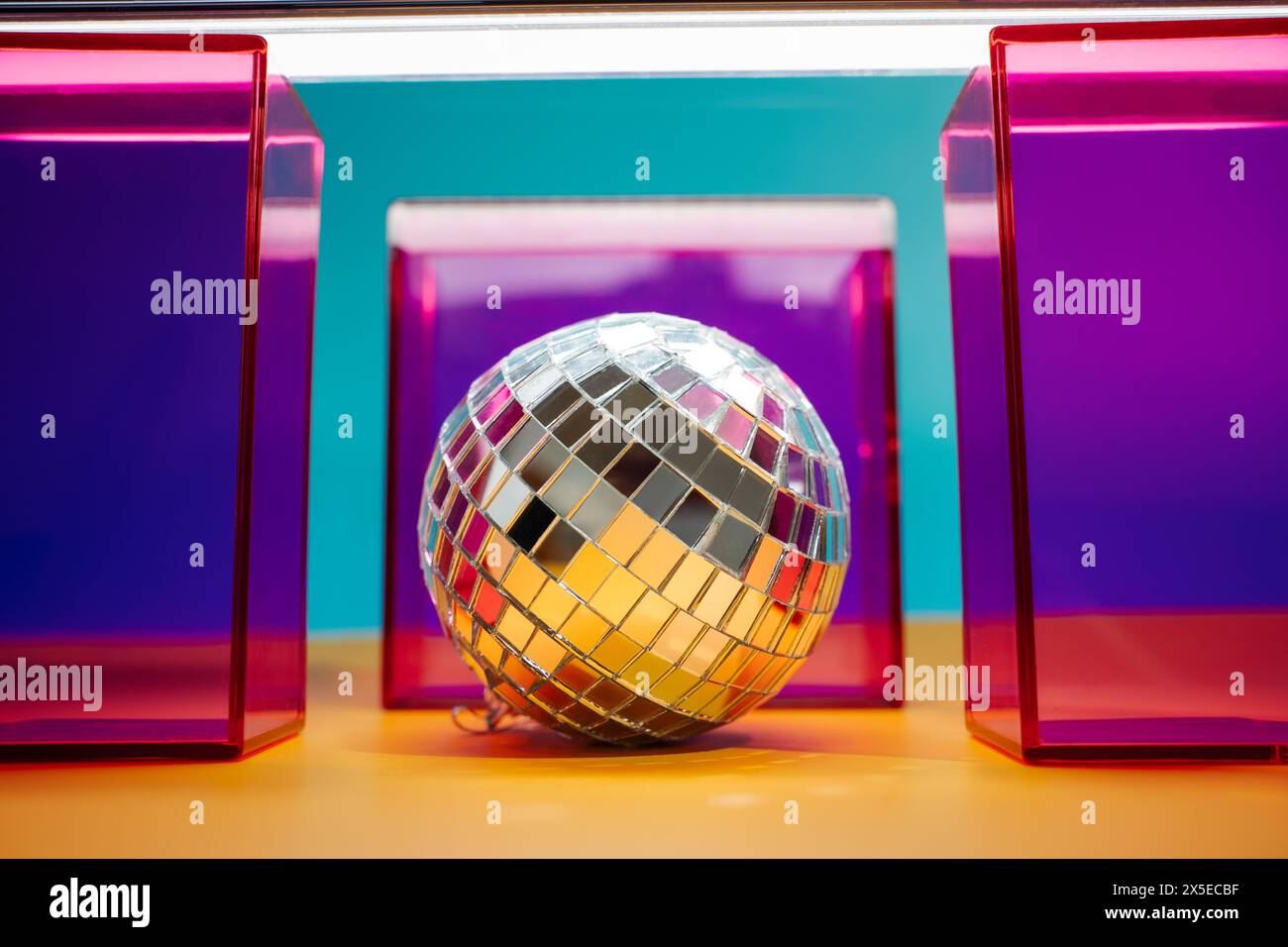 Mirror disco ball on yellow and blue background with vivid pink ...