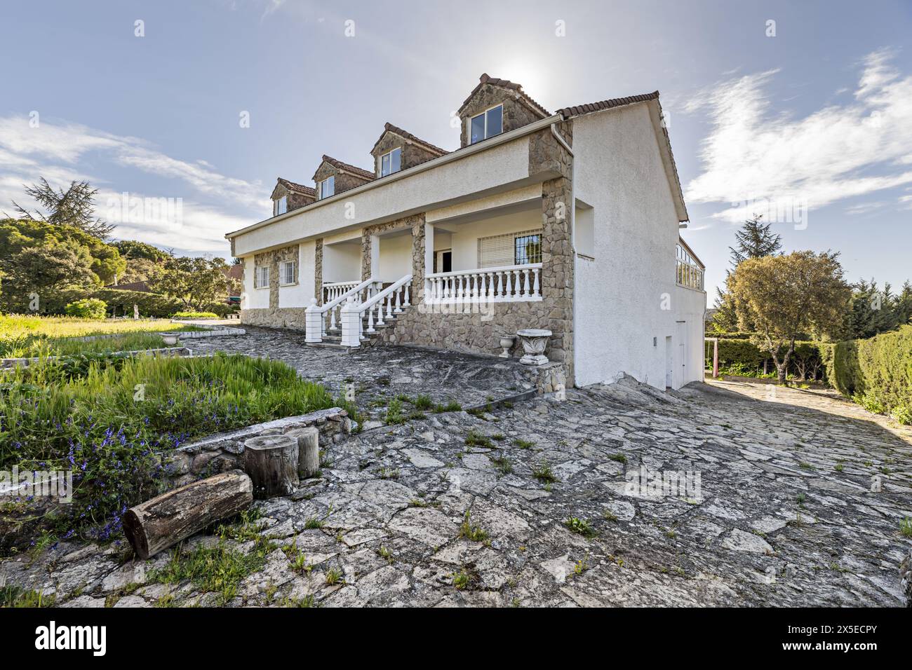 Villa facade with plot with granite stone floors, a ramp to the garage ...