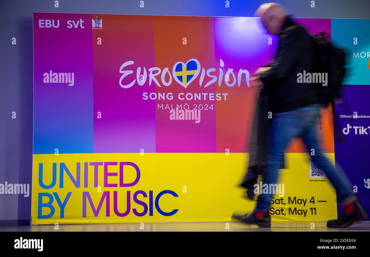 09 May 2024, Sweden, Malmö: A man walks past an advertising wall for ...