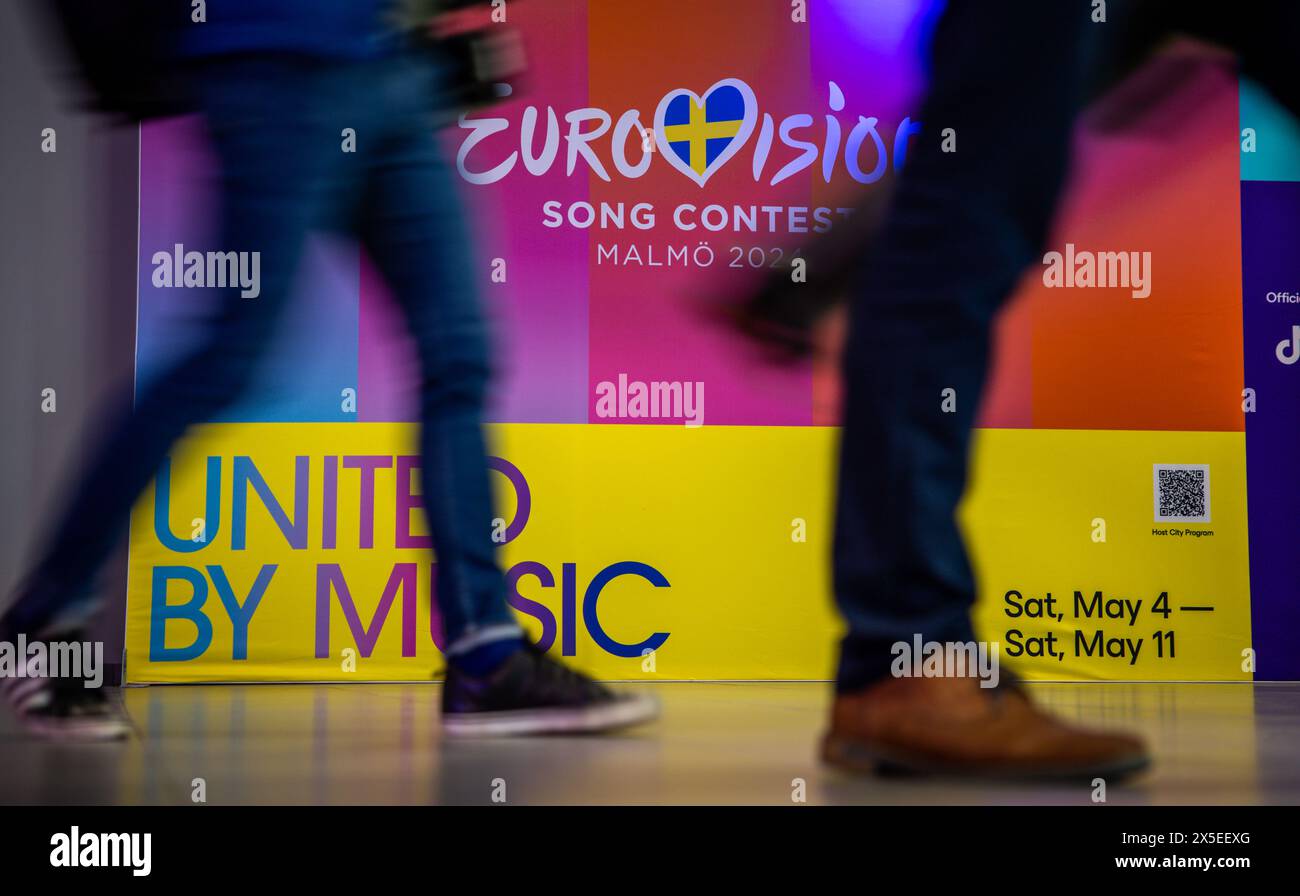 09 May 2024, Sweden, Malmö: Visitors walk past an advertising wall for ...