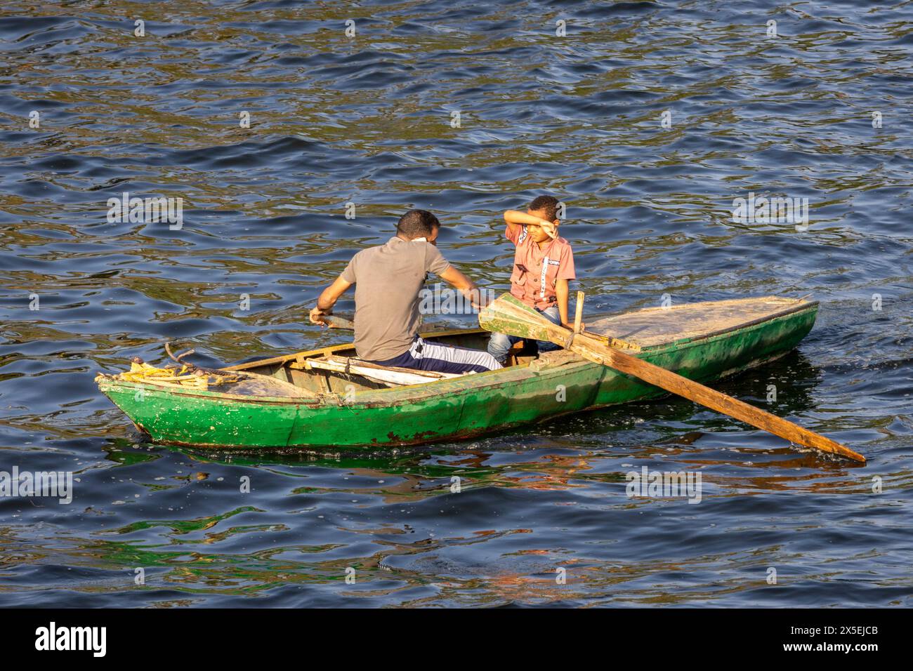 Local Egyptians fishing on the Nile River in Egypt. Small row boats are ...