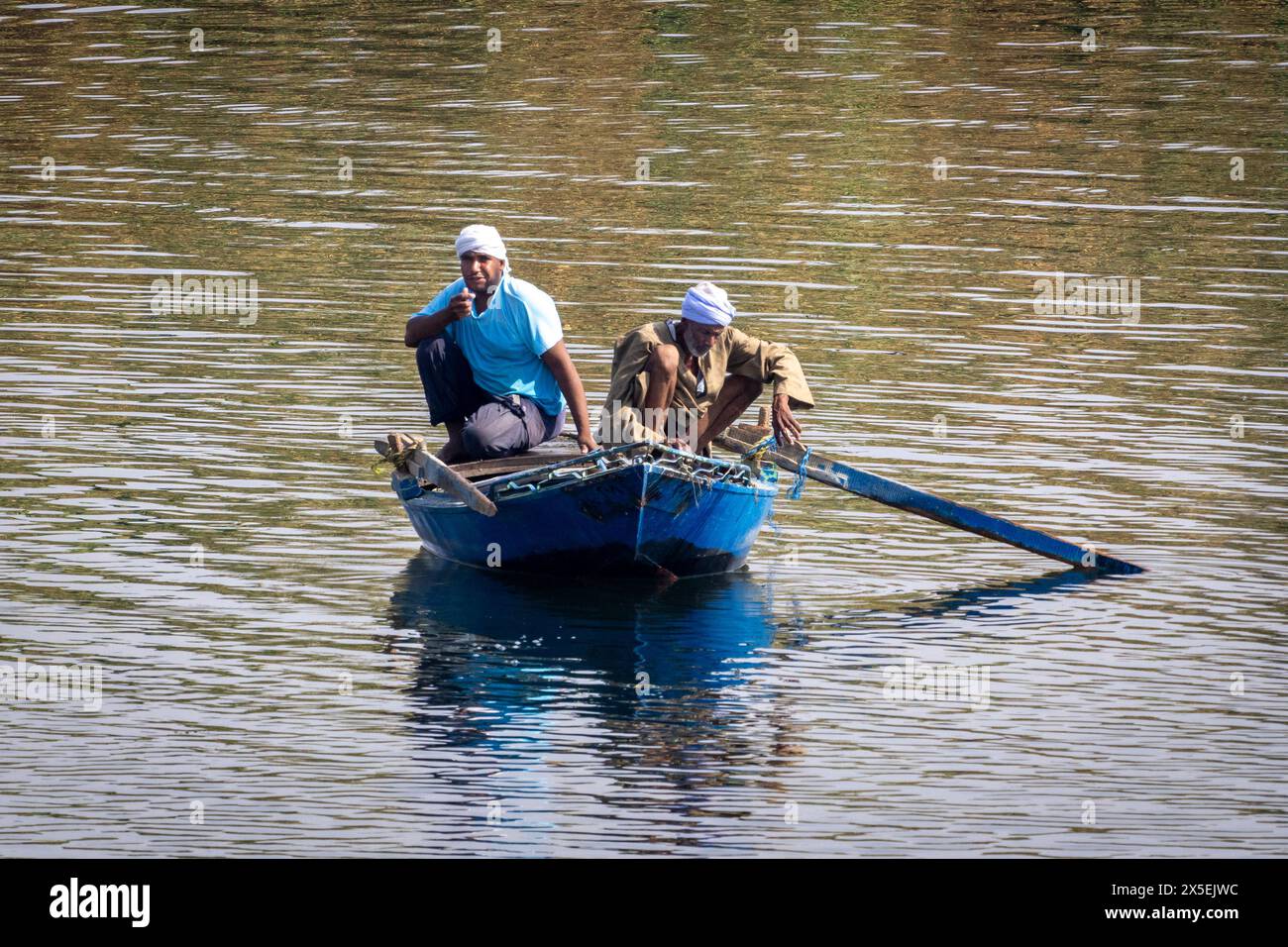Local Egyptians fishing on the Nile River in Egypt. Small row boats are ...