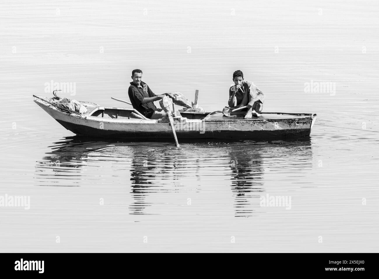 Local Egyptians fishing on the Nile River in Egypt. Small row boats are ...