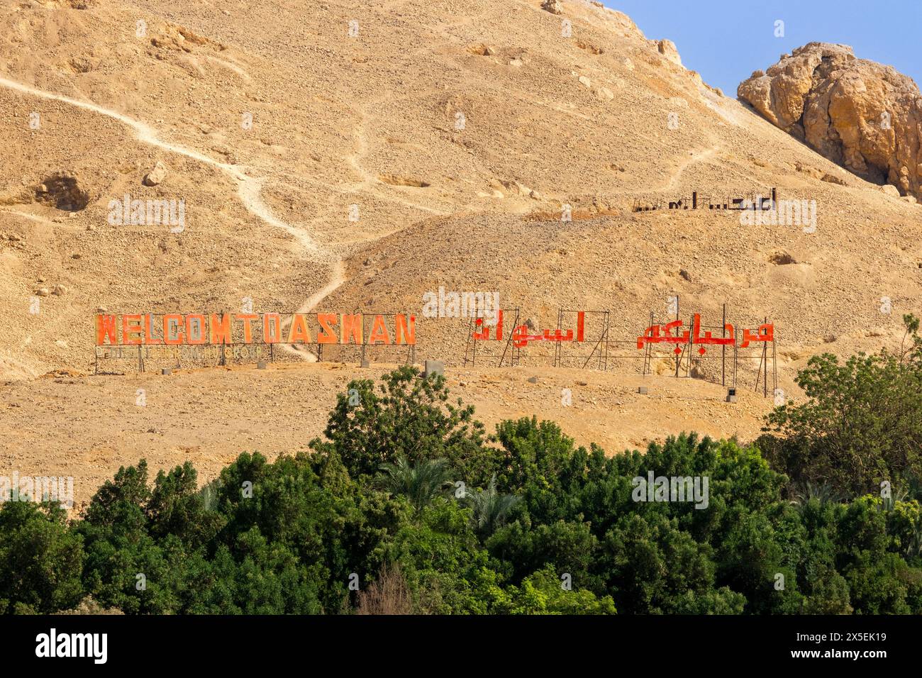 The Welcome To Aswan sign on the embankment of the Nile River and just ...