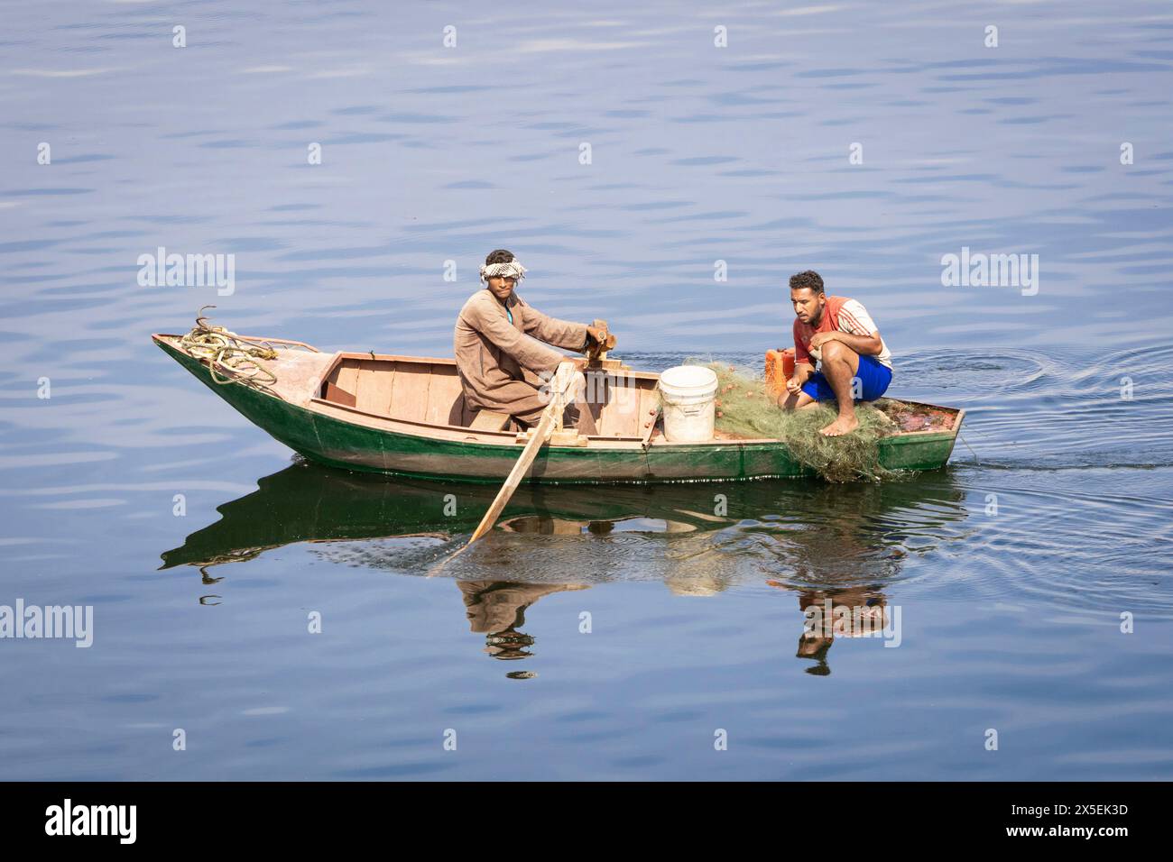 Local Egyptians fishing on the Nile River in Egypt. Small row boats are ...
