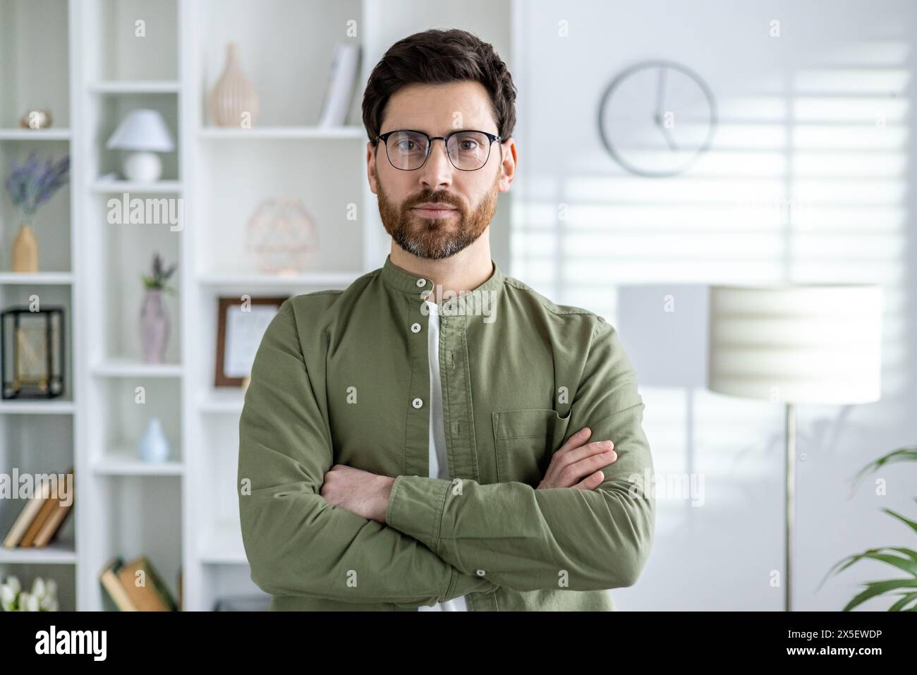 A professional man poses confidently with crossed arms in a ...