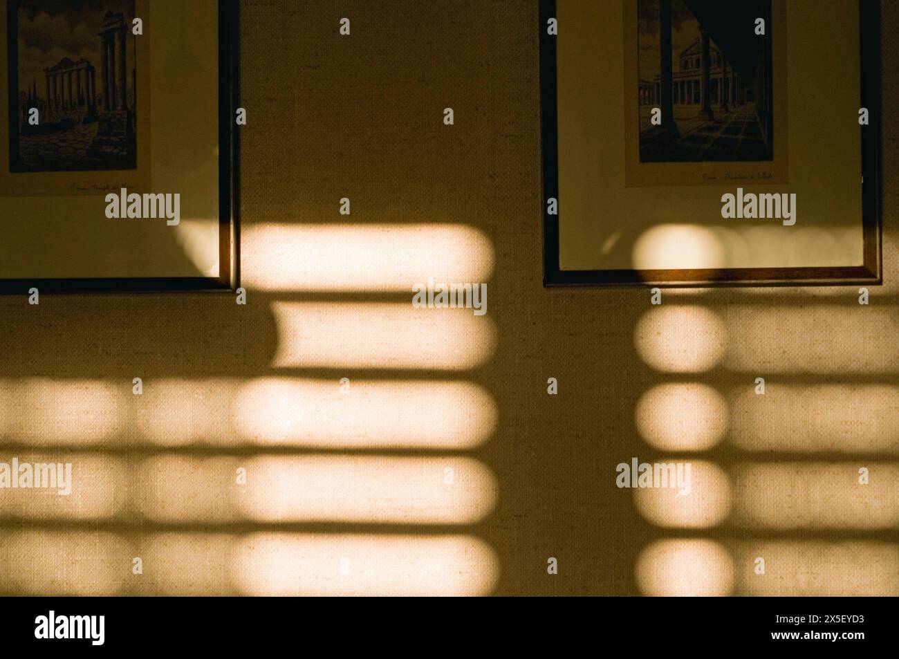 Framed prints and sunlight patterns through window Stock Photo - Alamy