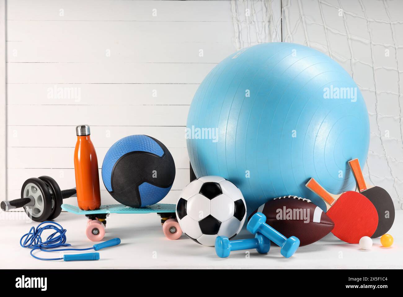 Many different sports equipment on white table Stock Photo - Alamy