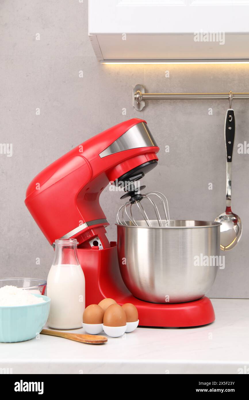 Modern red stand mixer and products on white table in kitchen Stock ...