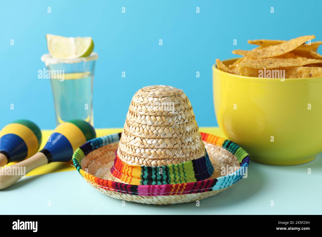 Mexican sombrero hat, nachos chips, maracas and tequila on color ...