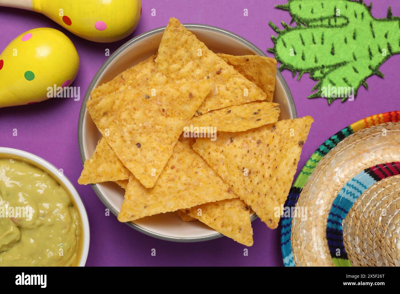 Nachos chips, maracas, guacamole, Mexican sombrero hat and paper cactus ...