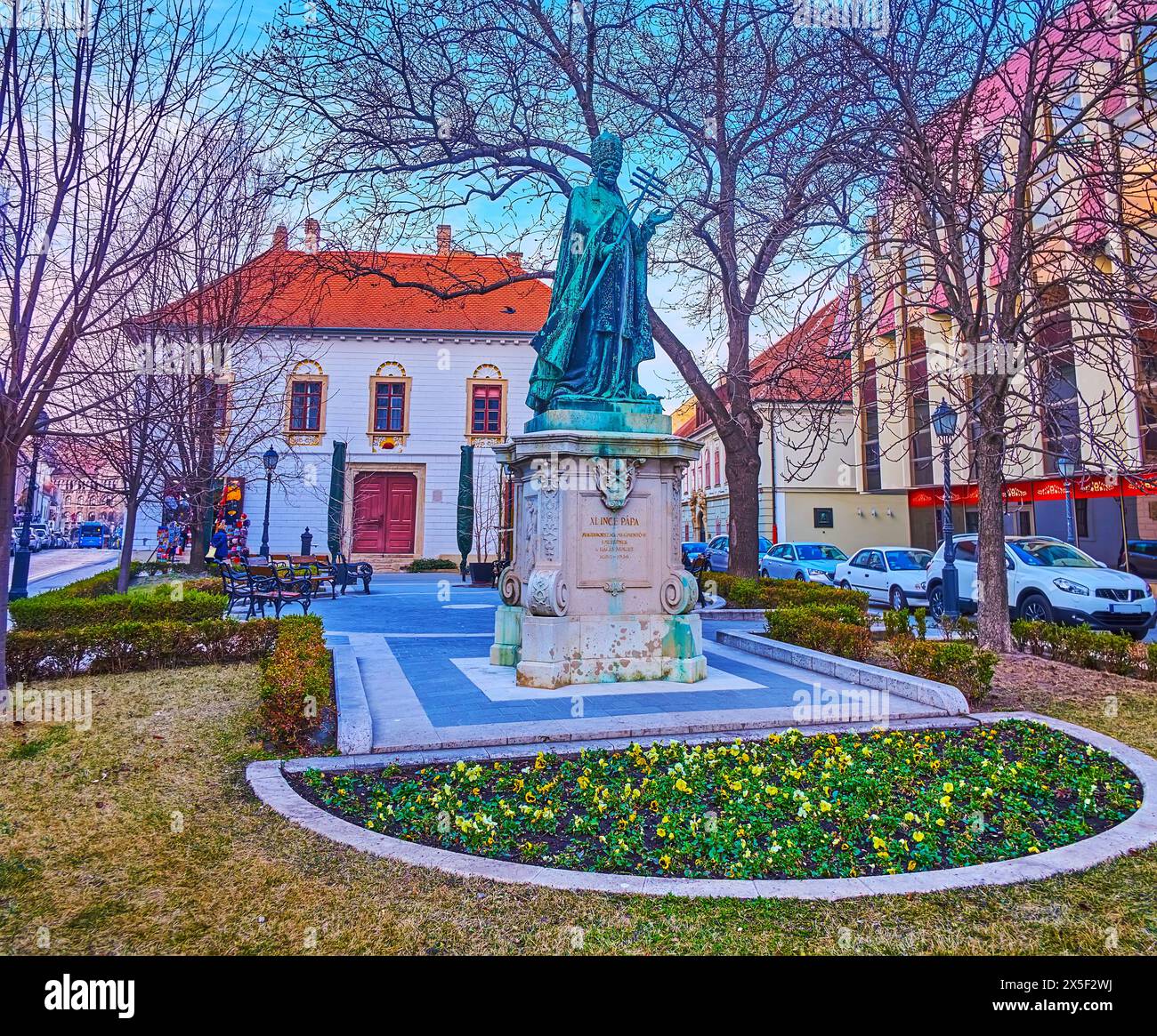 The bronze statue of Pope Innocent XI in the small park with flower ...