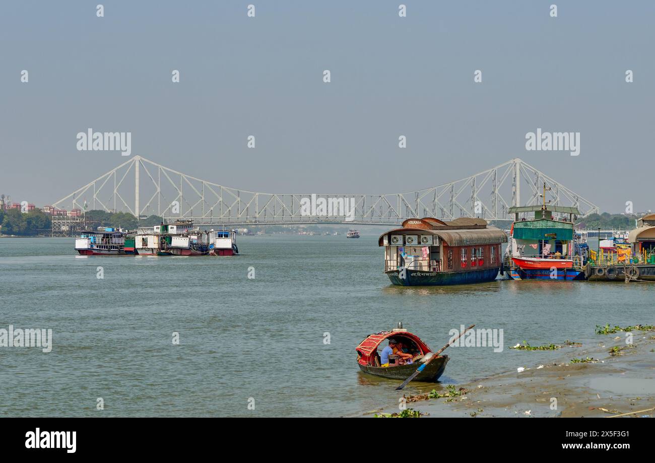 Busy waterway of the Hooghly river with Howrah Bridge in the background ...