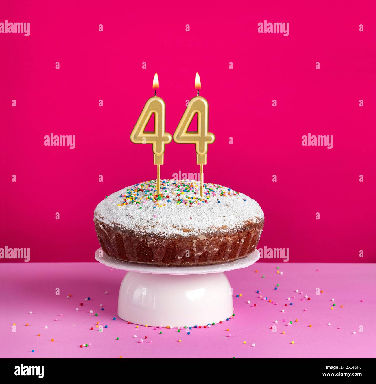 Lighted birthday candle number 44 - Birthday card on pink background ...