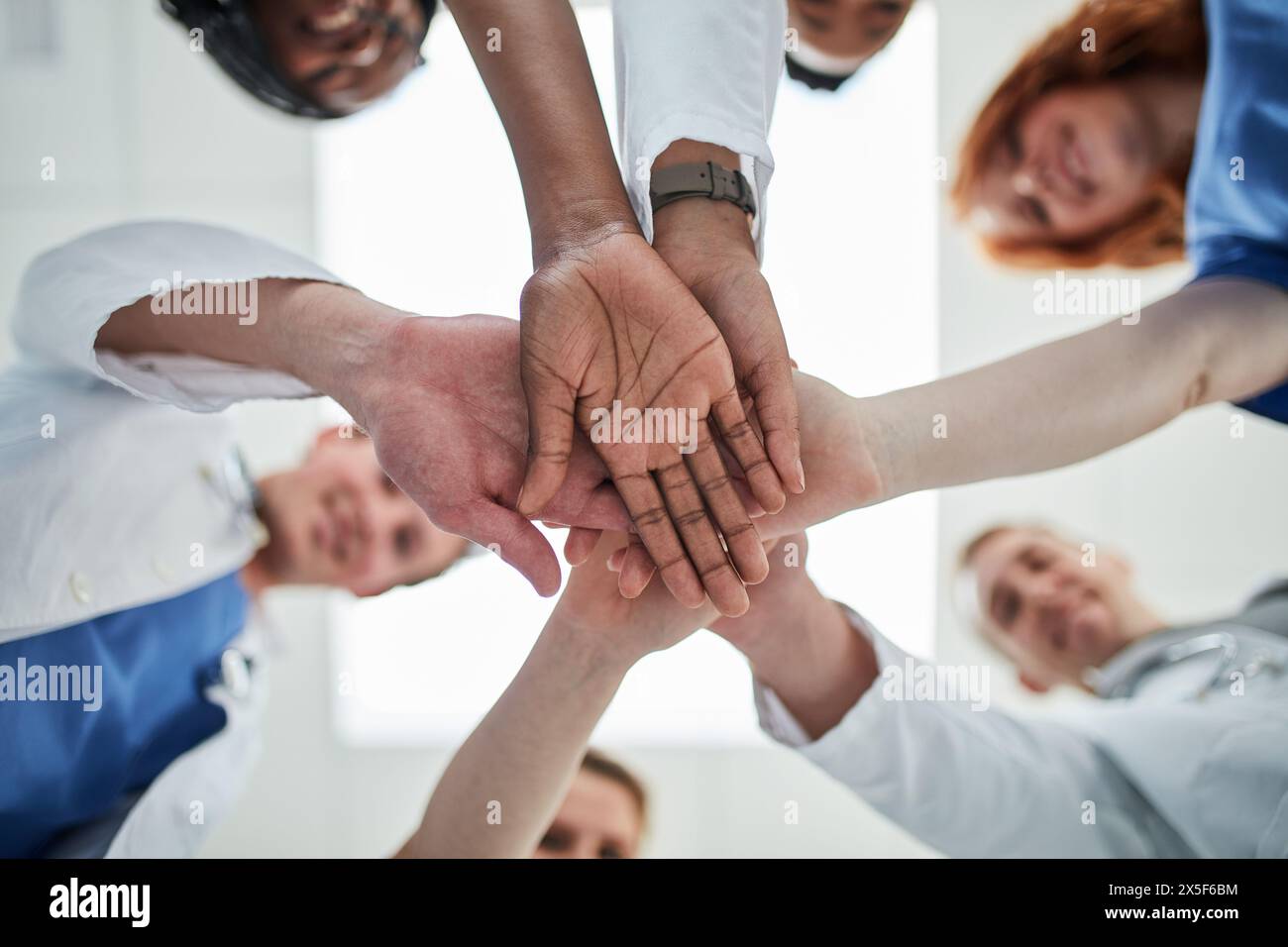 People, hands together and below with medical team for meeting, unity ...