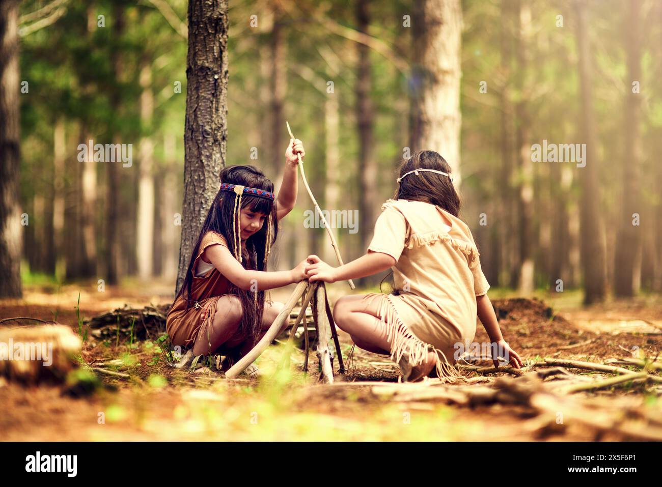 Native American children, girl and outdoor for campfire with helping ...