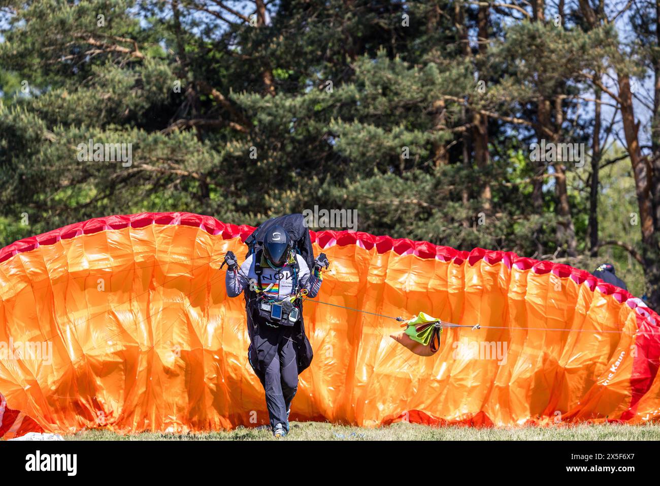 Cottbus, Germany. 09th May, 2024. A paraglider pilot and his glider are ...
