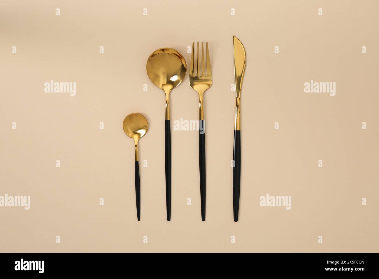 Stylish golden cutlery set on beige background, flat lay Stock Photo ...