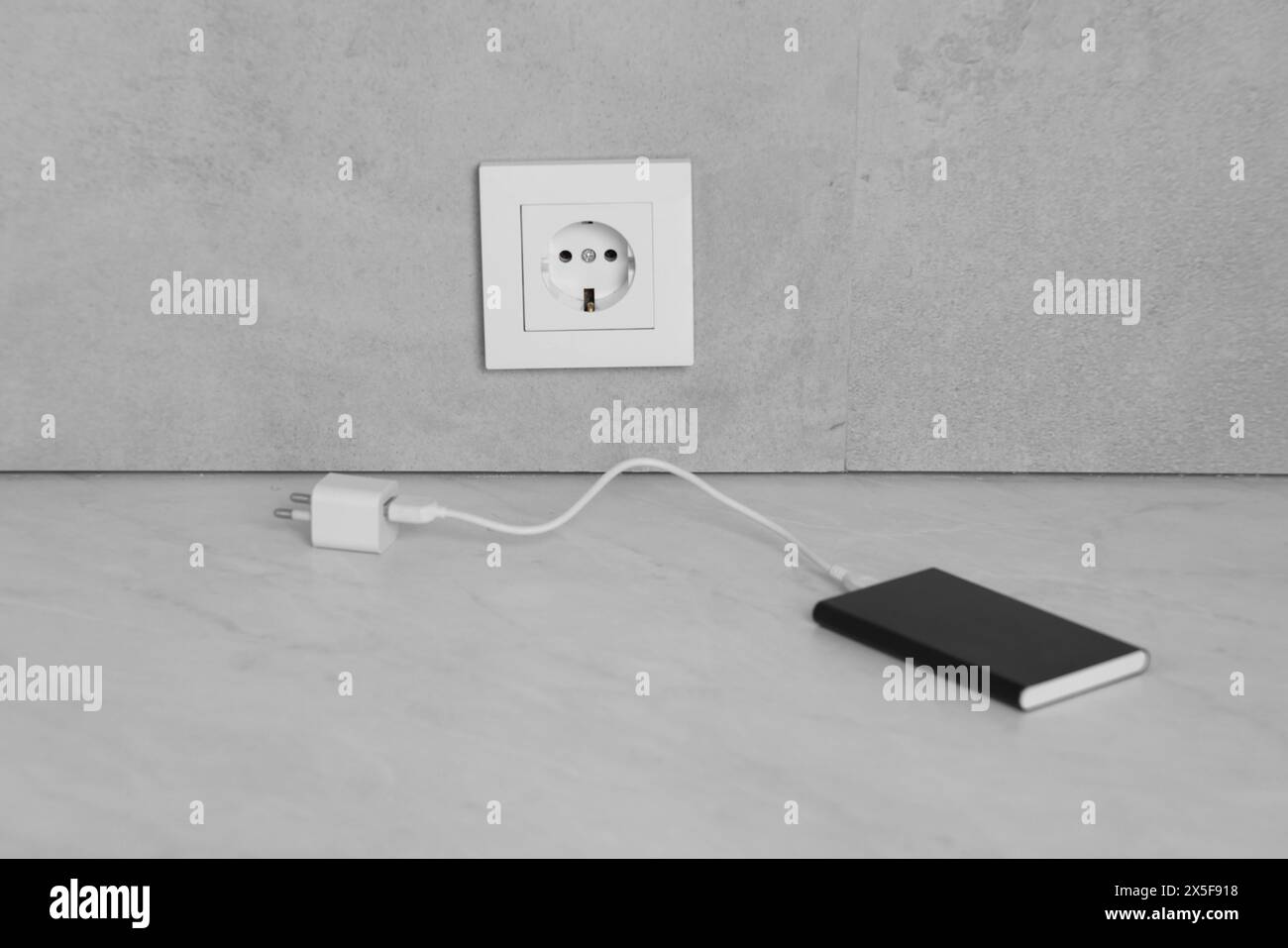 Electric socket and power bank on white table Stock Photo - Alamy