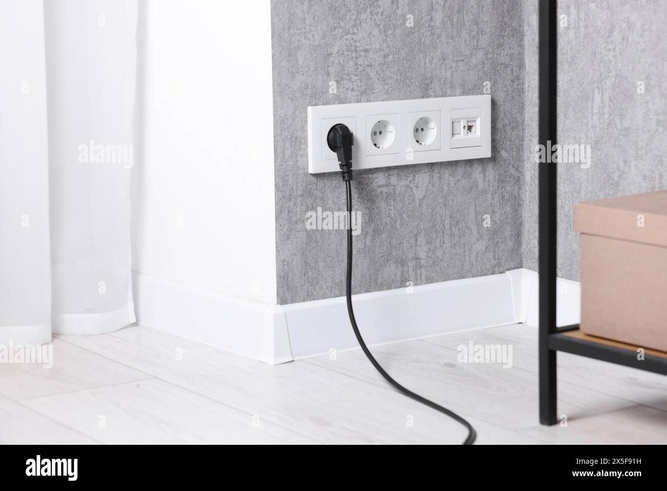 Power sockets and electric plug on grey wall Stock Photo - Alamy