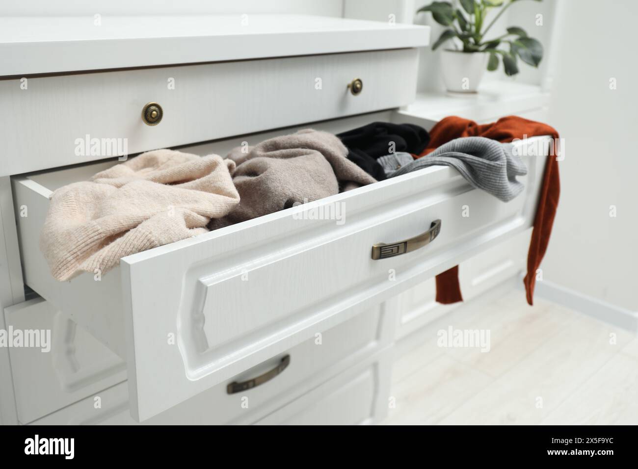 Cluttered chest of drawers indoors. Clothes in mess Stock Photo - Alamy