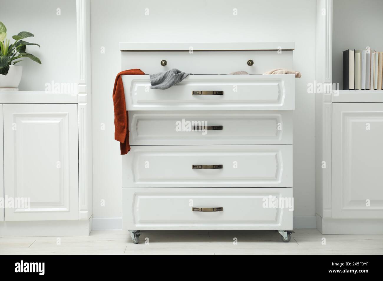 Cluttered chest of drawers indoors. Clothes in mess Stock Photo - Alamy