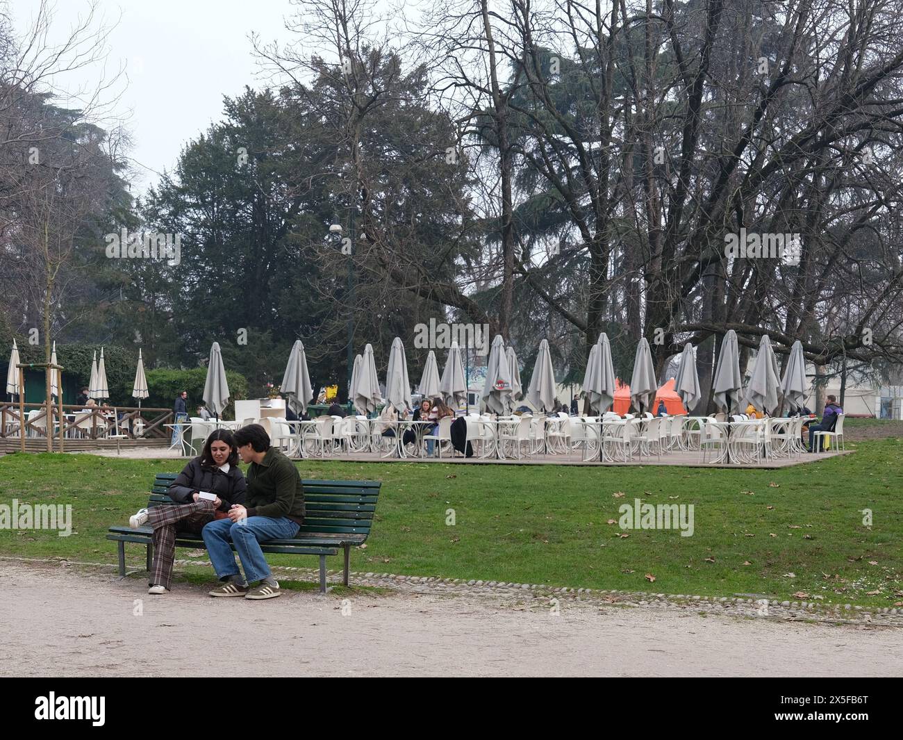 Milan, Italy - Feb 02 2024: Boy and girl sitting on bench in front of ...
