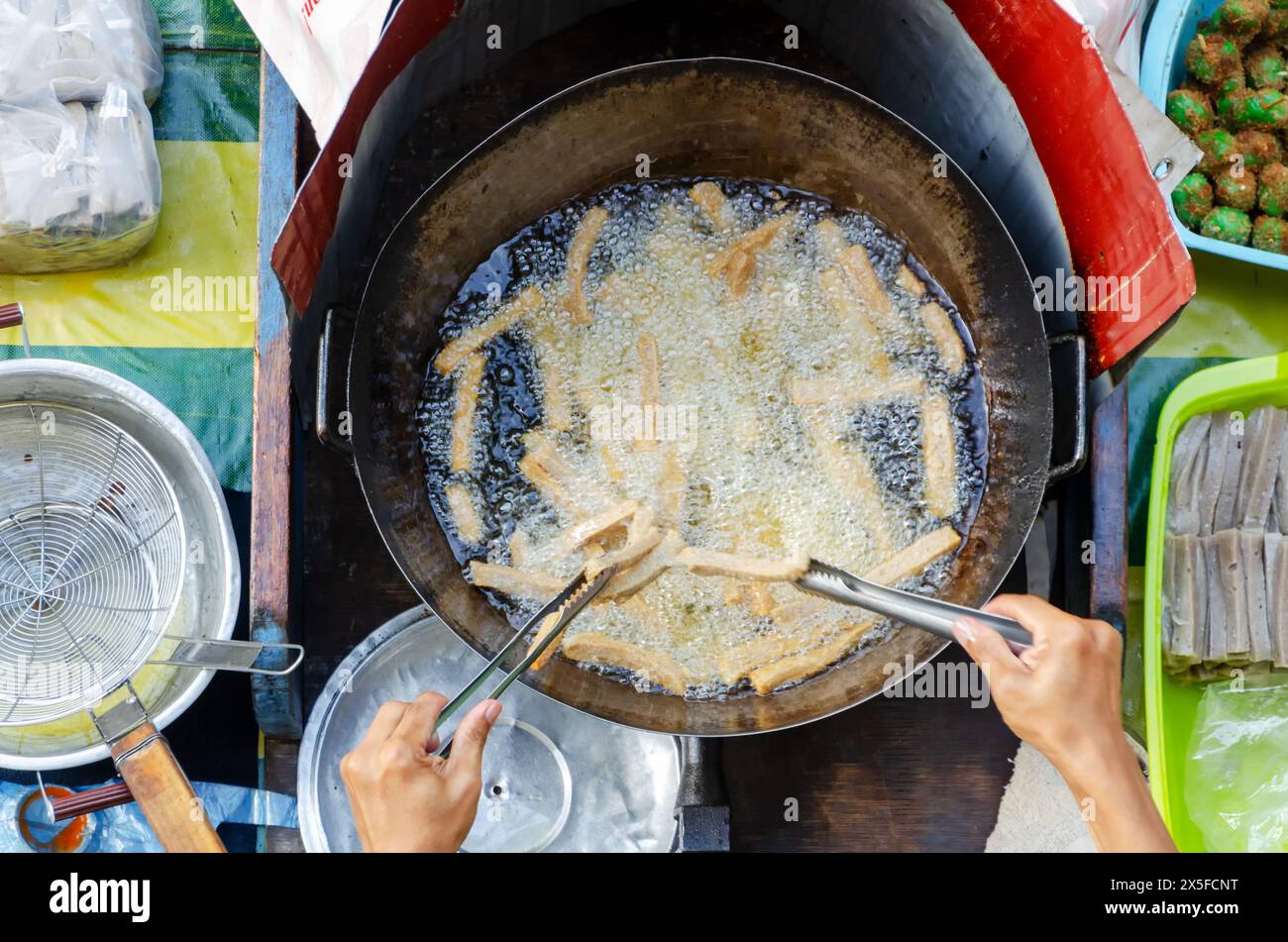 Deep frying Malaysian fried fish snacks called Keropok Lekor Stock ...