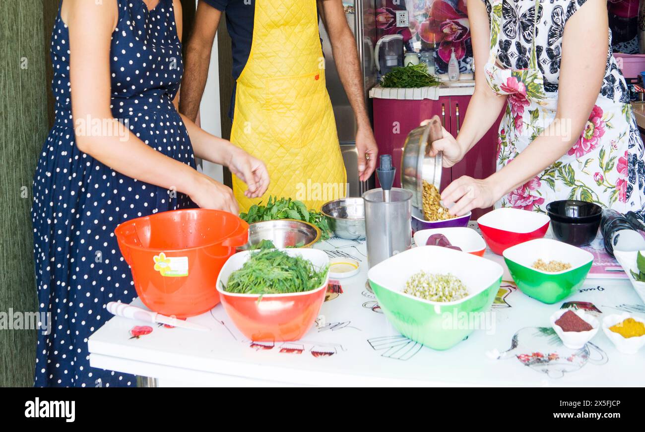Group of diverse young friends preparing vegetarian meals together in ...