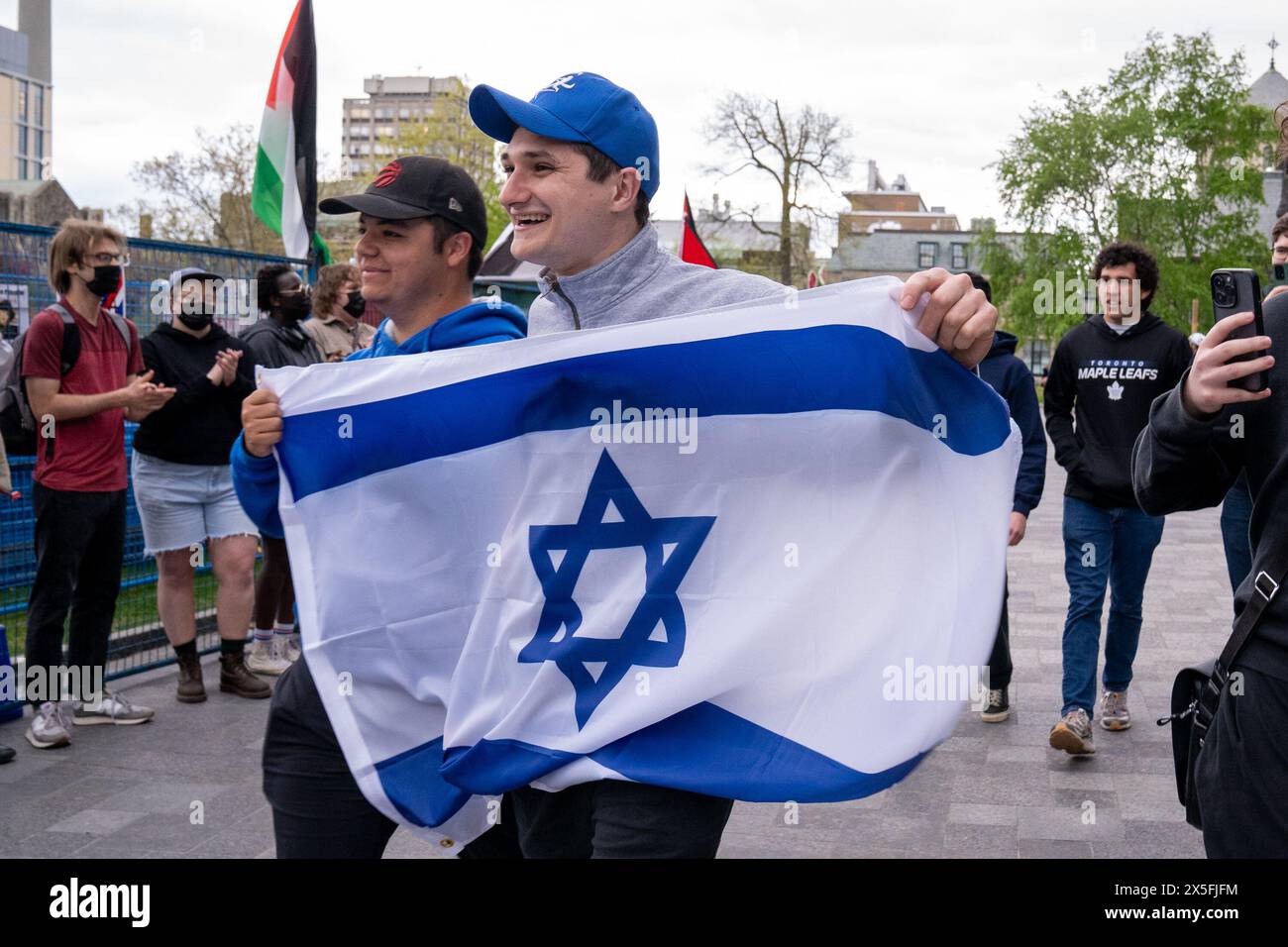 Pro-Israel supporter holding Israeli flag walks through crowd as pro ...
