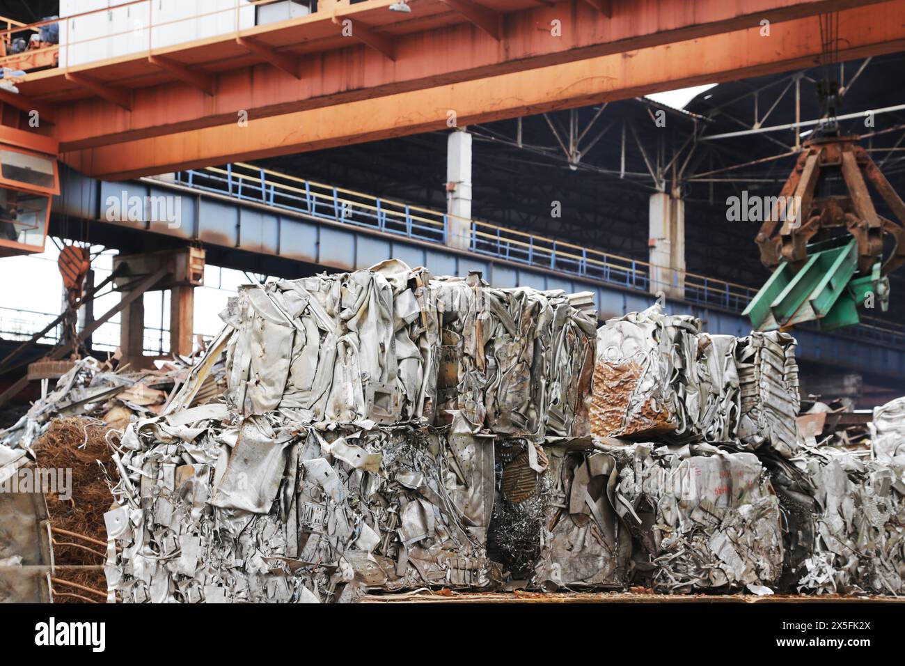 Scrap yard, pressing non-ferrous scrap metal into a cube. Recycling of ...