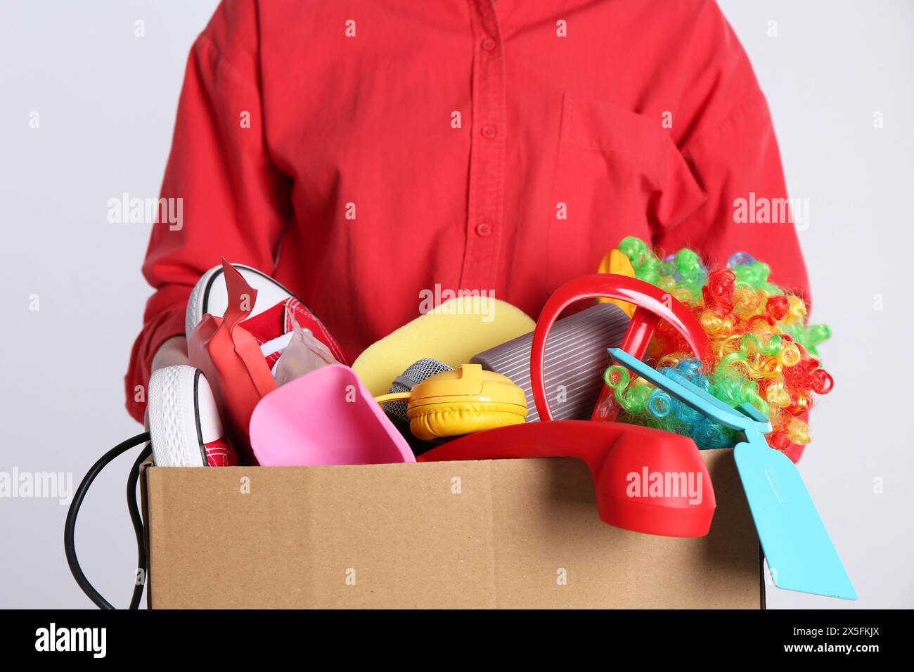 Woman holding box of unwanted stuff on white background, closeup Stock ...