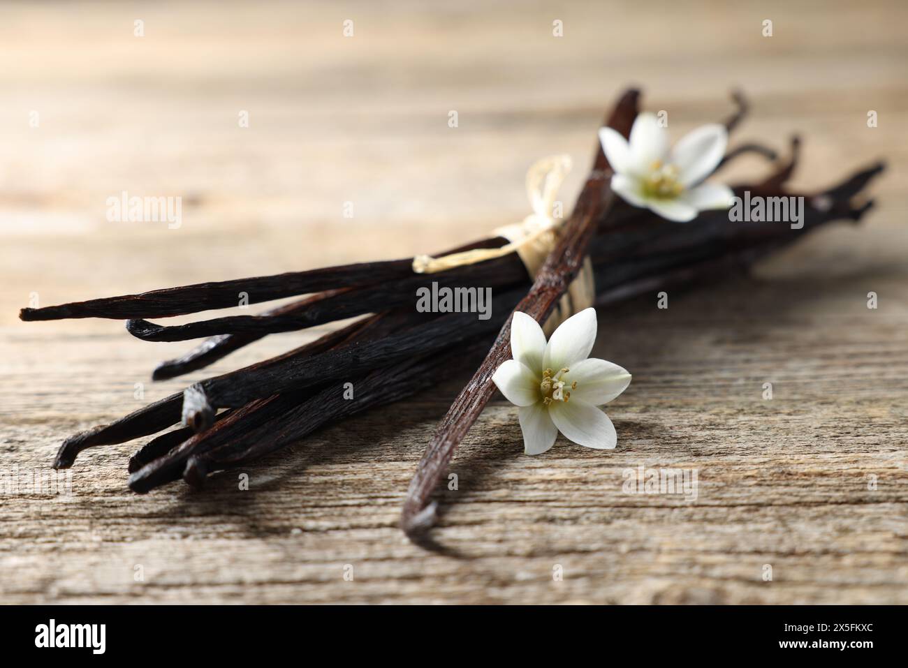 Bunch of vanilla pods and flowers on wooden table, closeup Stock Photo ...