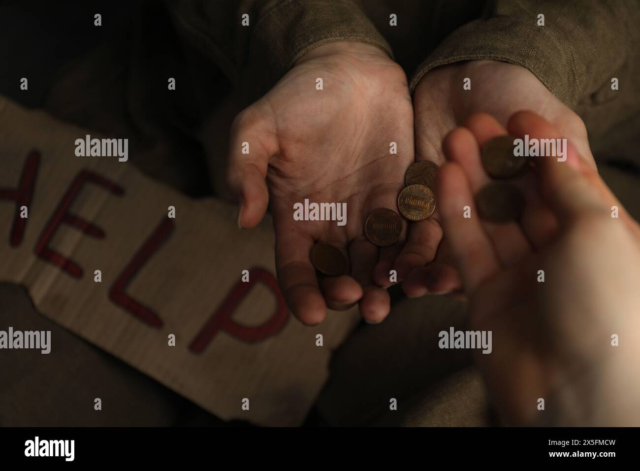 Woman giving coins to homeless, closeup. Charity and donation Stock ...