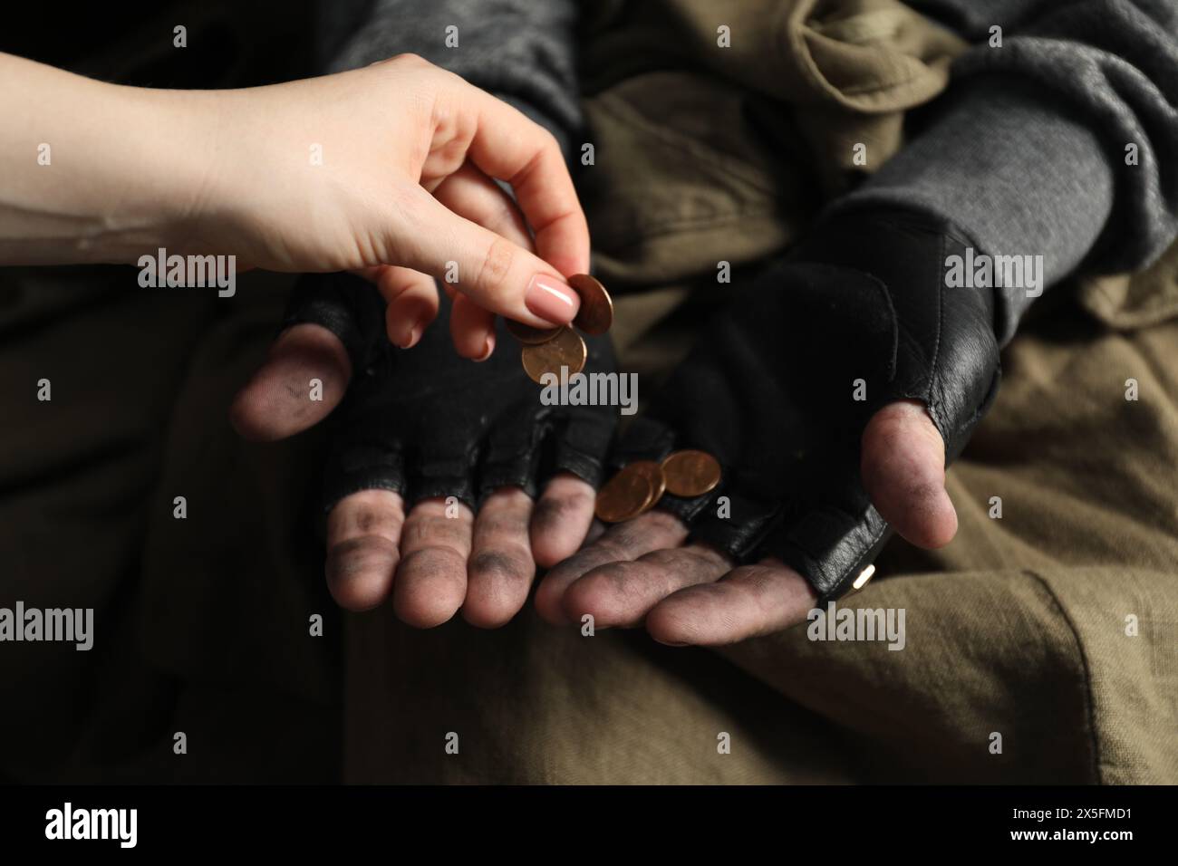 Woman giving coins to poor homeless man, closeup. Charity and donation ...