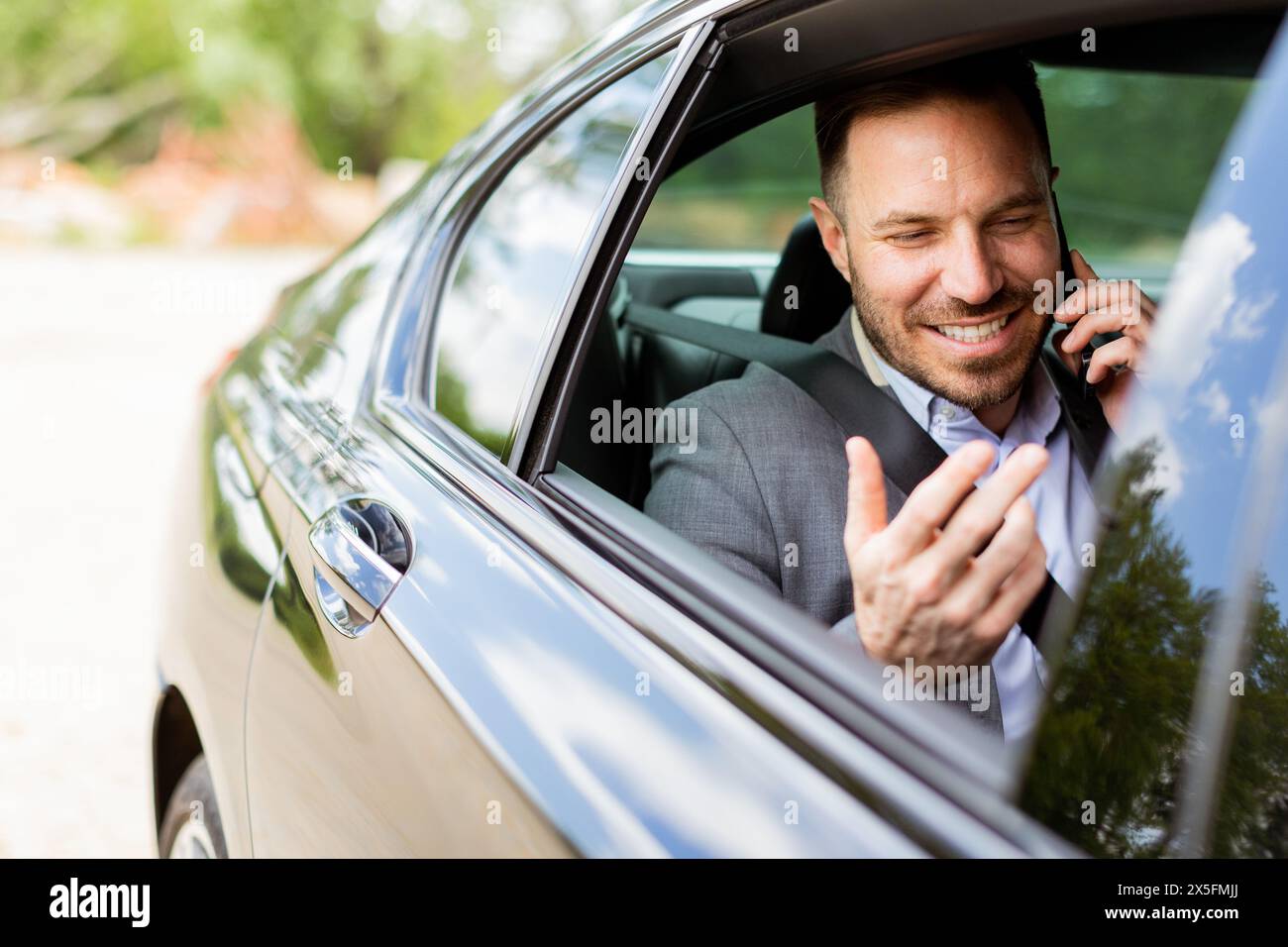 Man chuckles merrily during a car ride, enjoying a lively conversation ...