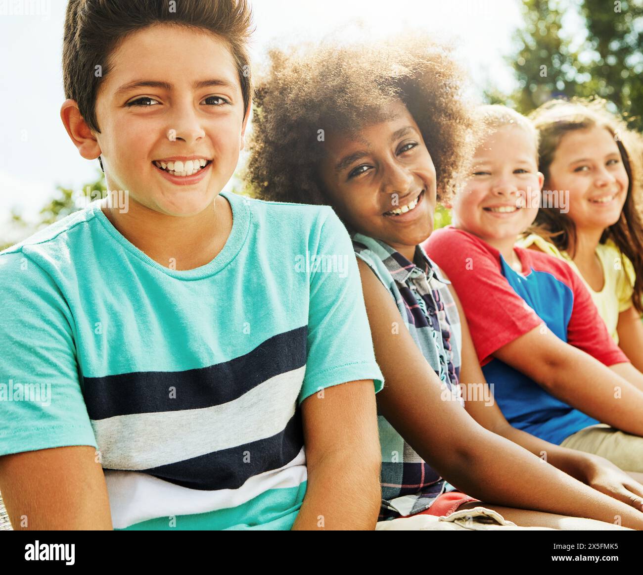 Portrait, outdoor and children on bench, diversity and playful with ...