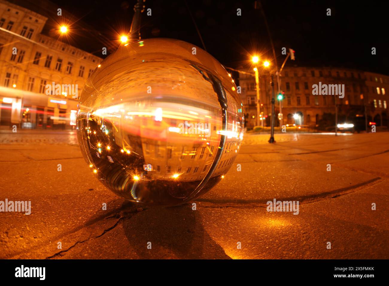 Beautiful city street, overturned reflection. Crystal ball on asphalt ...