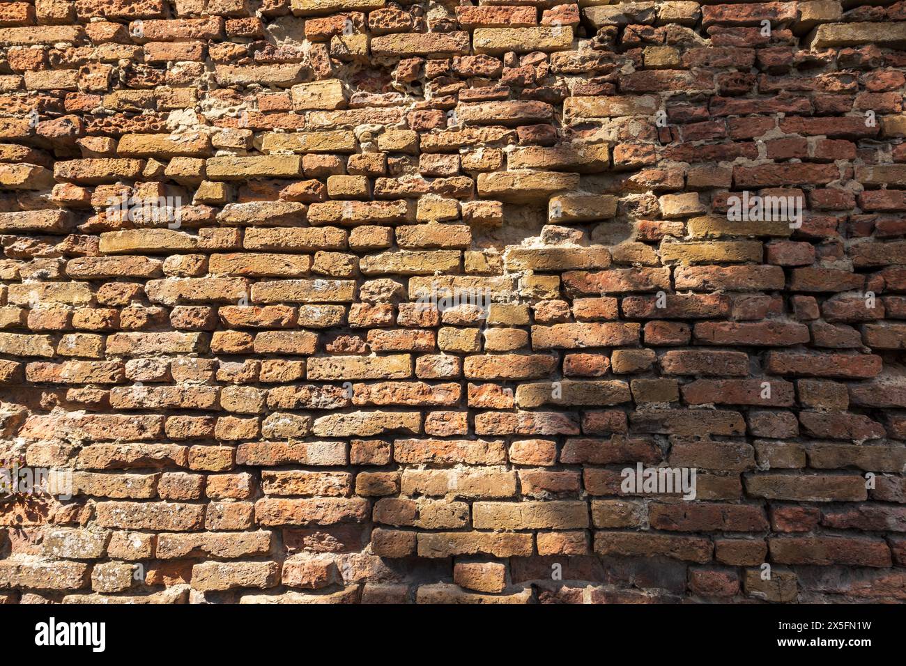 A rustic brick wall in the historic medieval city of Certaldo in ...