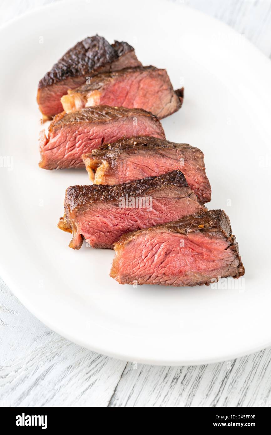 Sliced cooked strip steak on the plate Stock Photo - Alamy