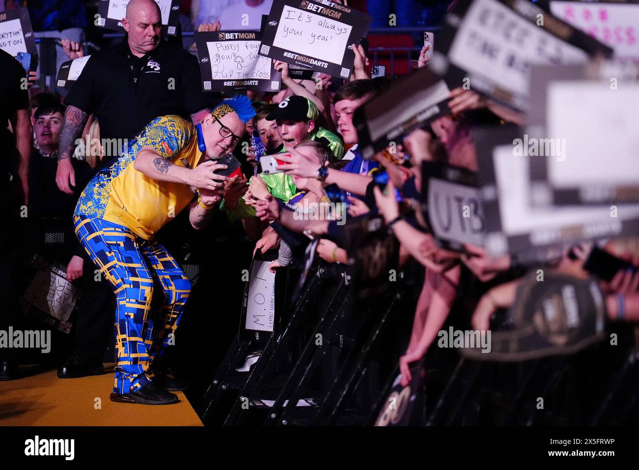 Peter Wright poses for photos while walking out to play Luke Littler ...