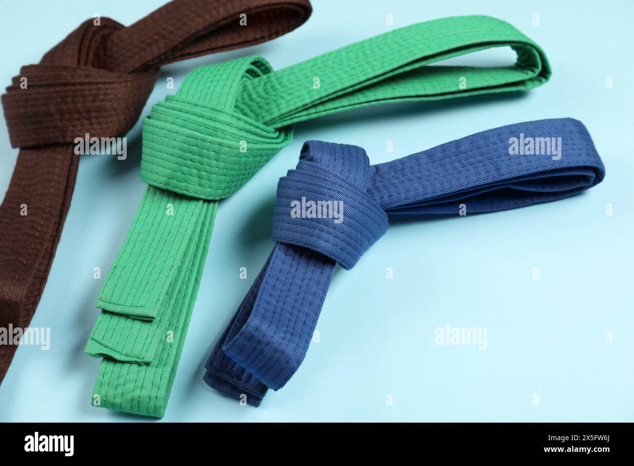 Colorful karate belts on light blue background, closeup Stock Photo - Alamy