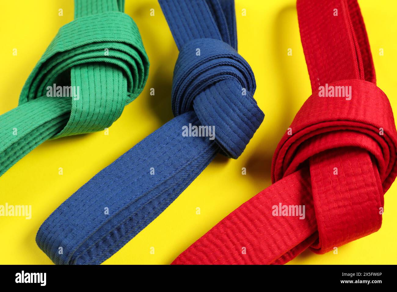 Colorful karate belts on yellow background, closeup Stock Photo - Alamy