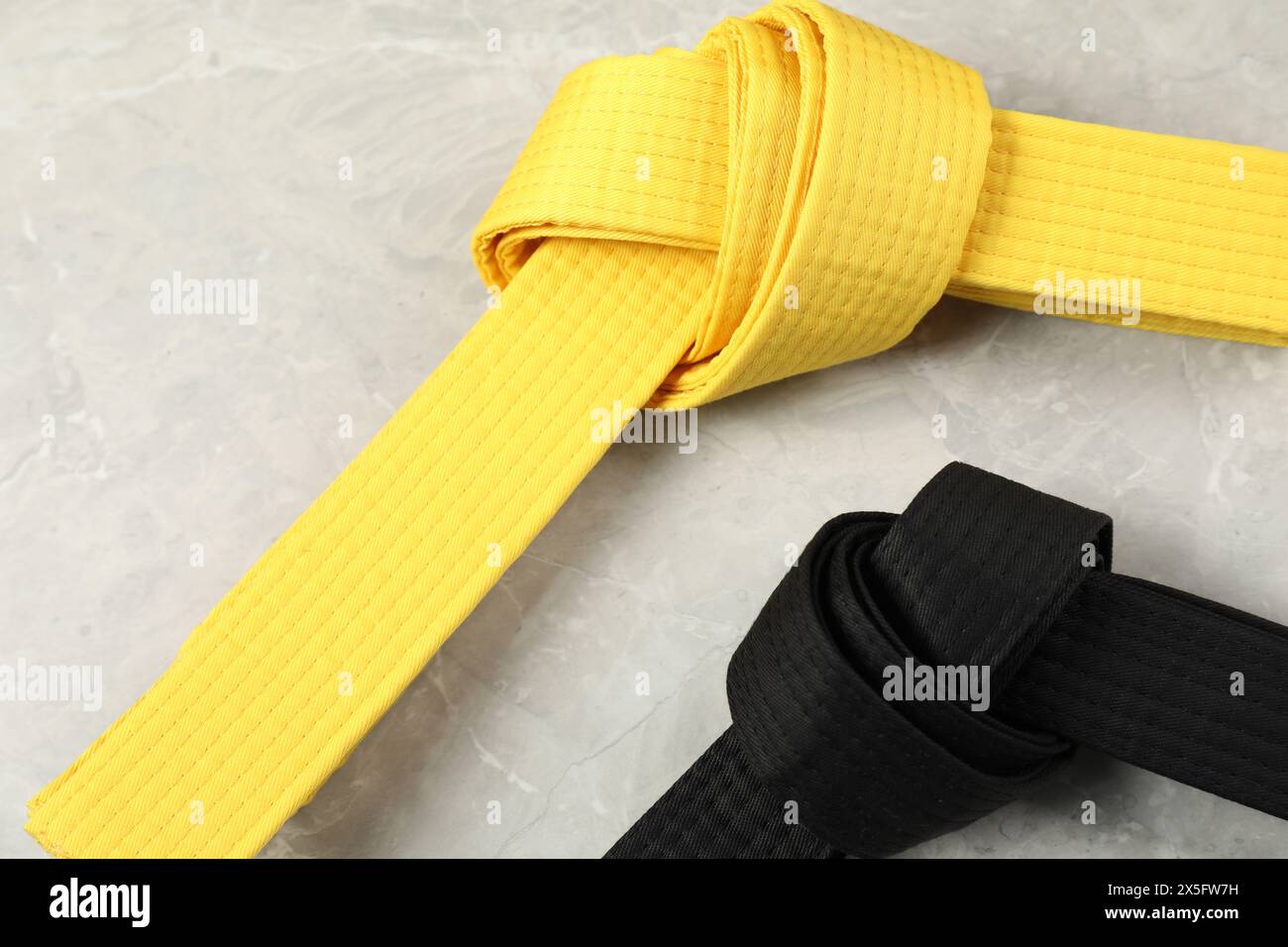 Black and yellow karate belts on gray marble background, closeup Stock ...