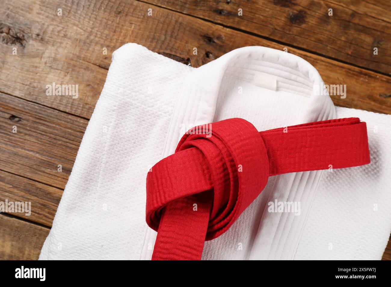 Red karate belt and white kimono on wooden background, top view Stock ...