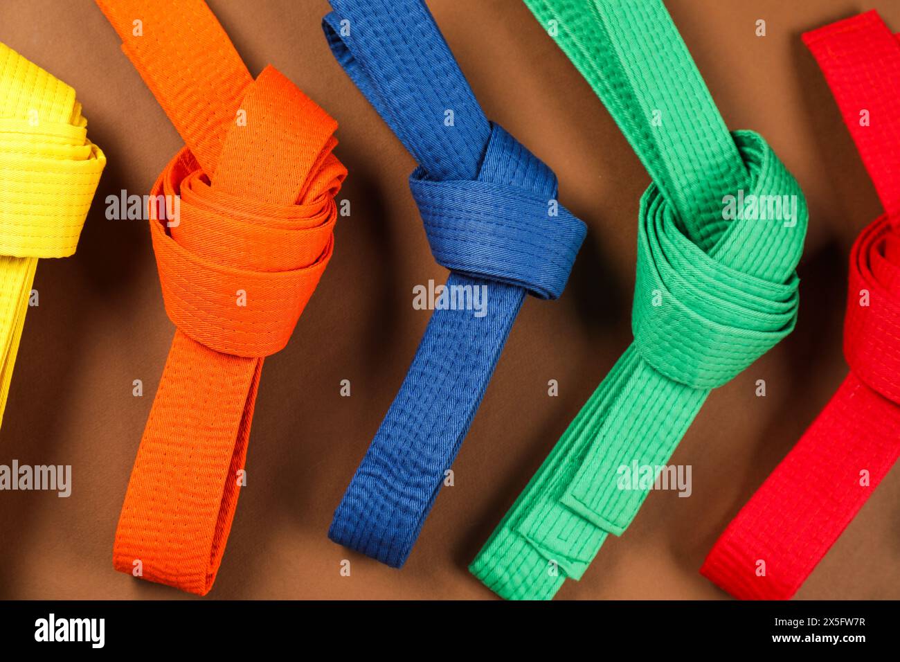 Colorful karate belts on brown background, flat lay Stock Photo - Alamy