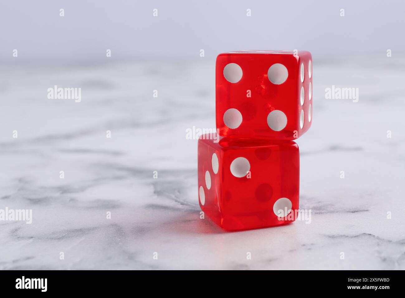 Two red game dices on white marble table, closeup. Space for text Stock ...