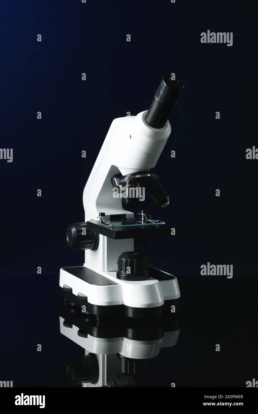 Modern medical microscope on black mirror surface Stock Photo - Alamy